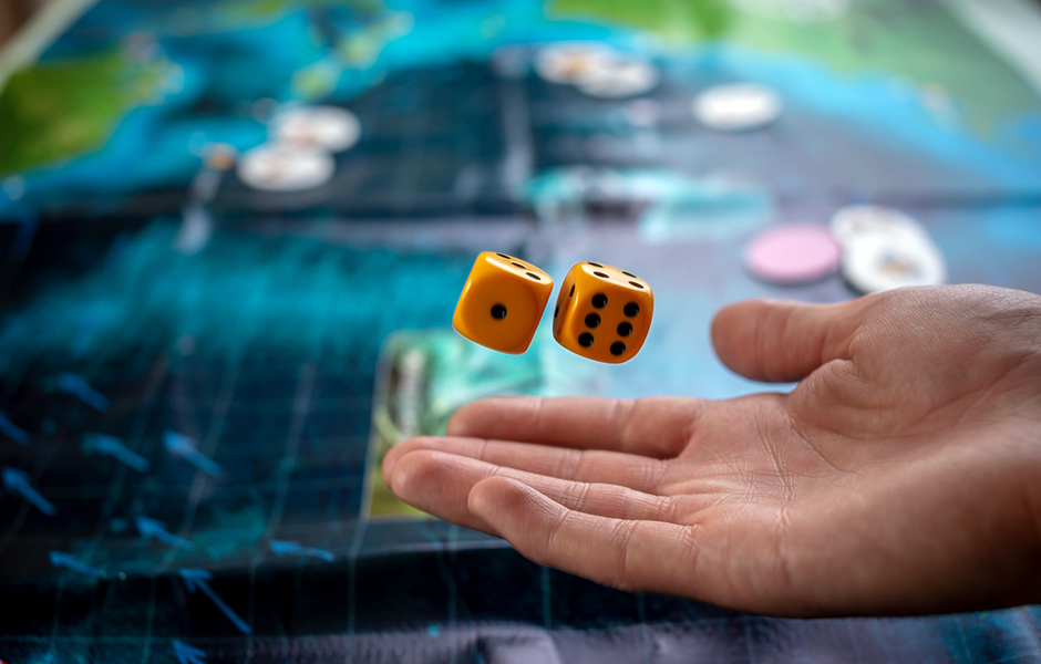 Hand throws yellow dice on the playing field. Luck and excitement ...