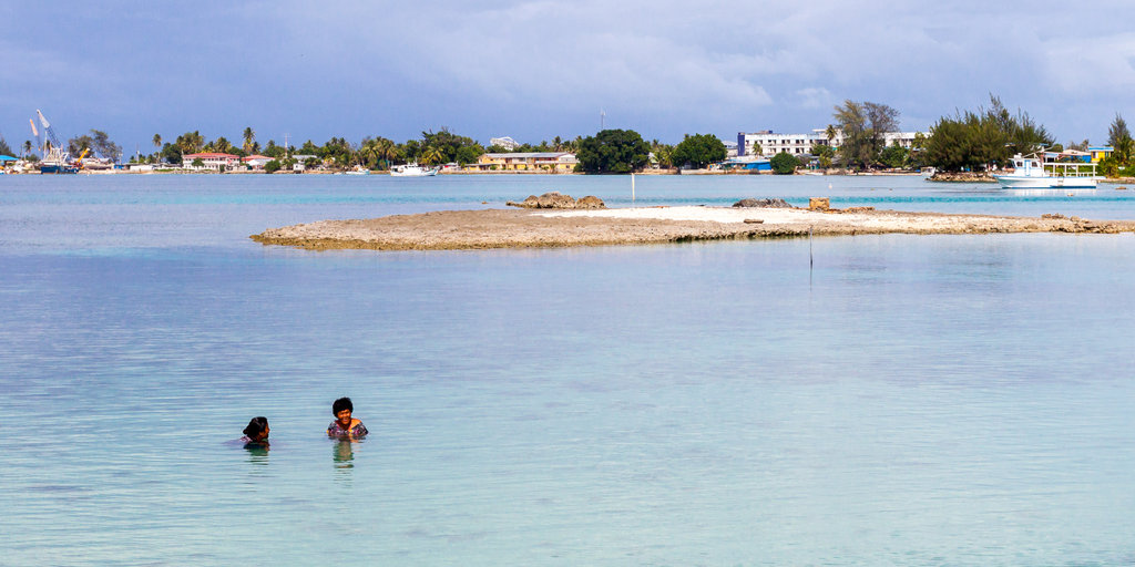 Two middle aged Micronesian women in closing enjoying swimming i ...